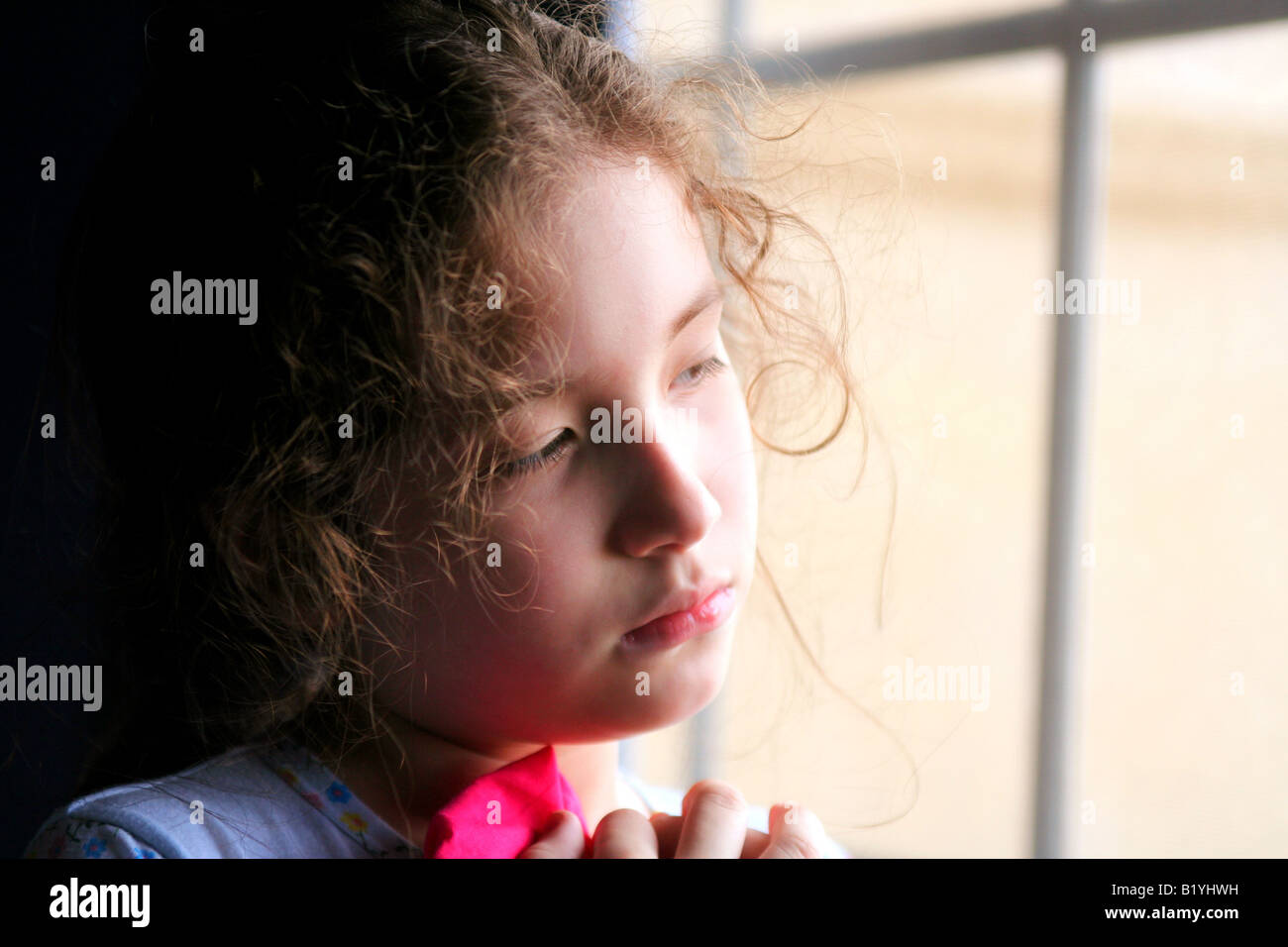 Pretty young girl melancholic staring outside the window Stock Photo ...