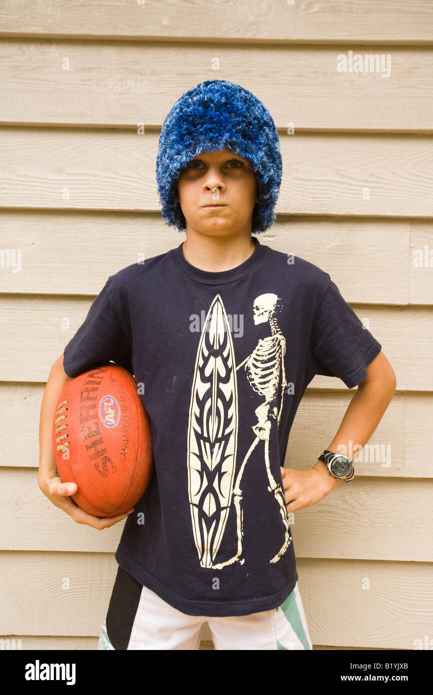 Serious tough boy with funny fluffy hat holding a rugby ball Stock ...