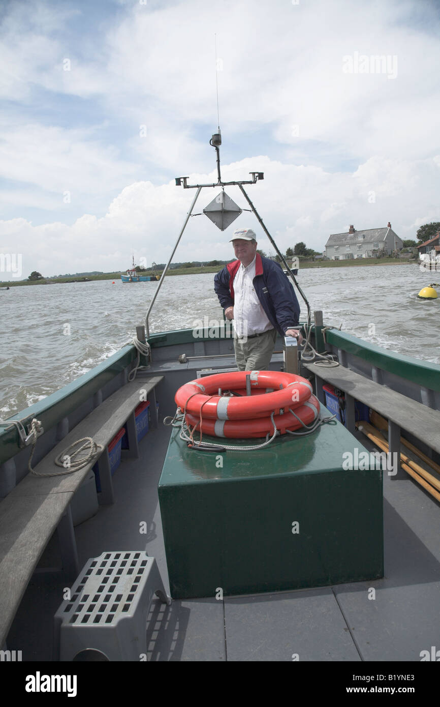 Ferryman steering ferry boat across River Ore from Orford to Orford ...