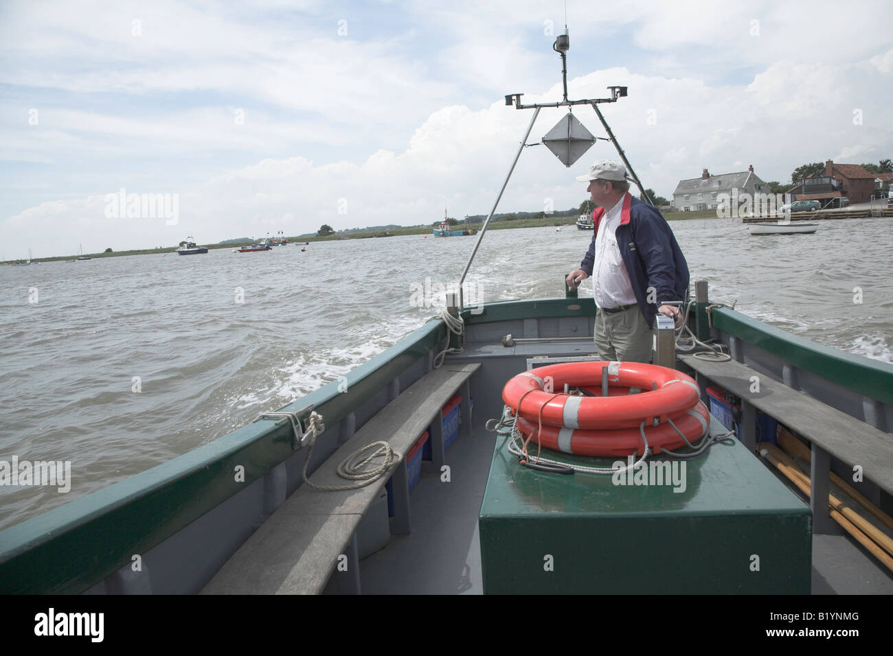 Ferryman steering ferry boat across River Ore from Orford to Orford ...
