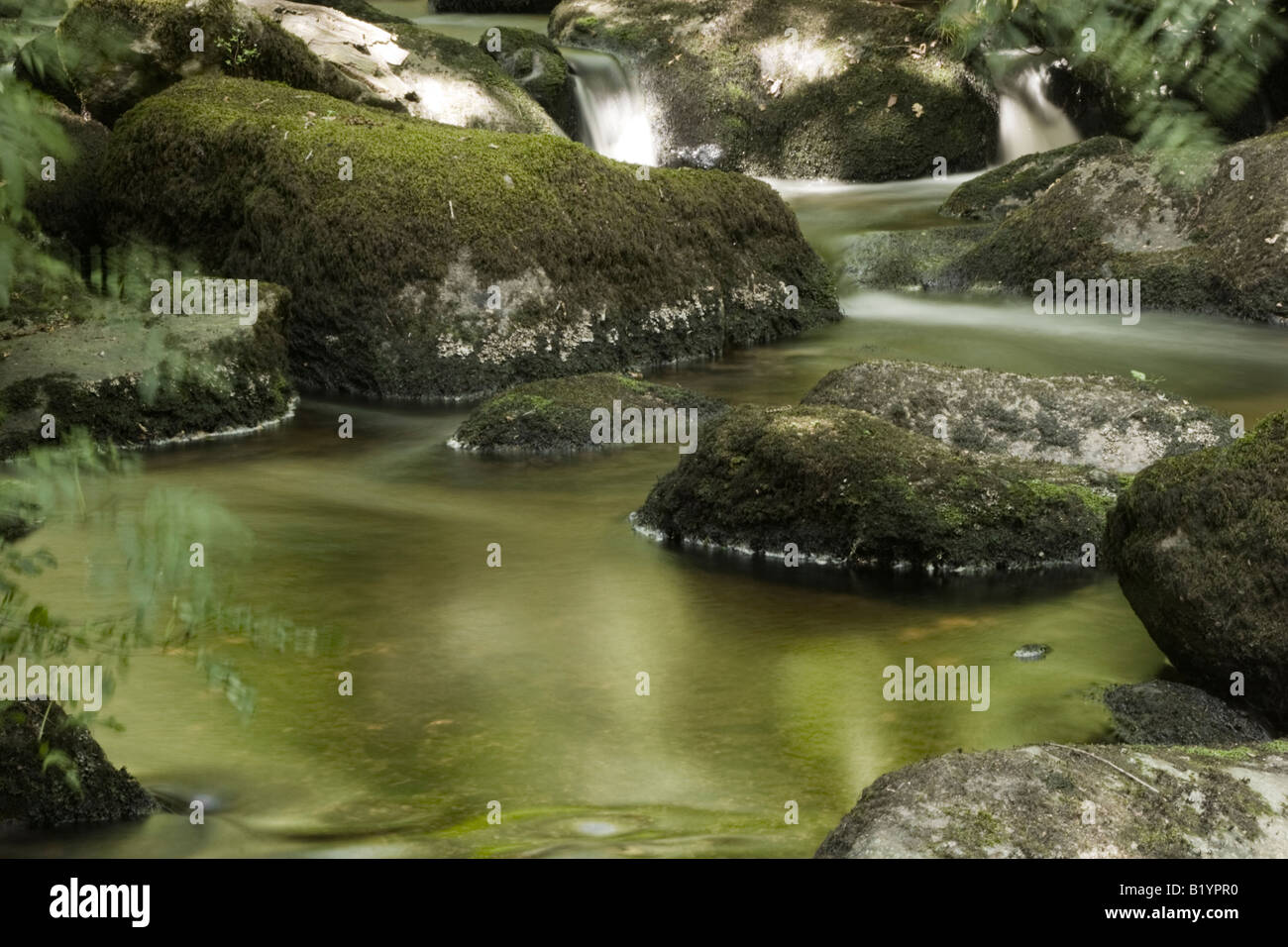 Granite waterfall and pool of clear, still water giving with a ...