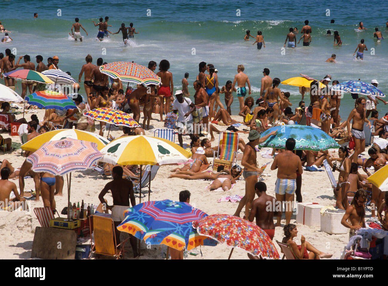 Sunbathers and swimmers gather on a beach in Copacabana along the Stock ...