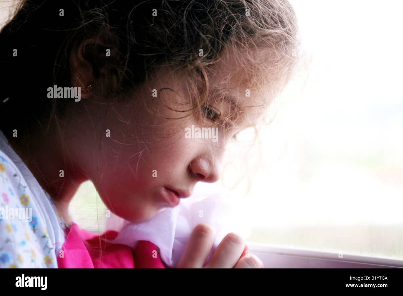 Pretty young girl melancholic staring outside the window Stock Photo ...