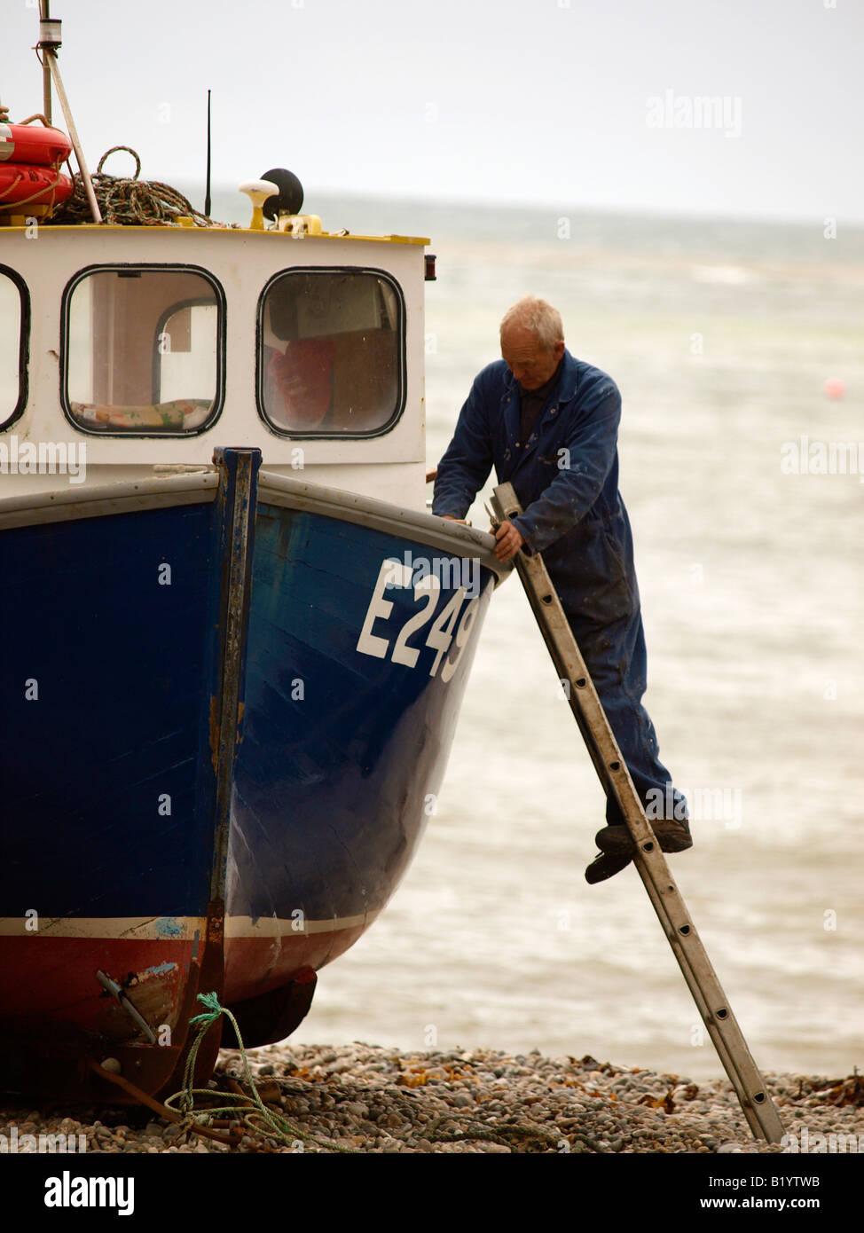 Fisherman repairs boat Stock Photo - Alamy