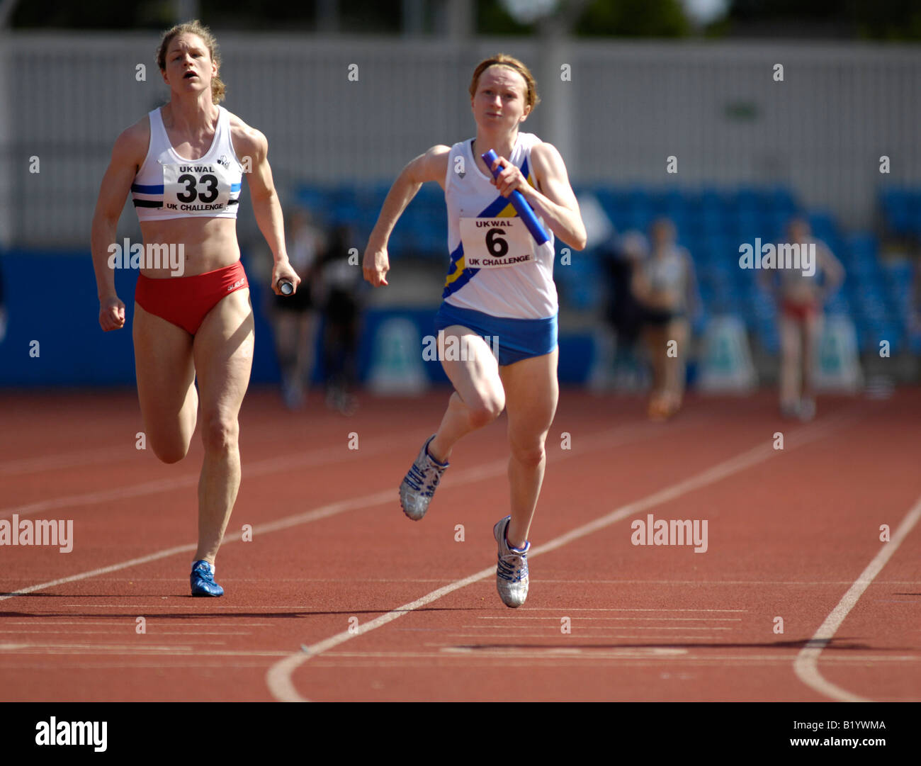 two relay runners sprinting for the line Stock Photo - Alamy