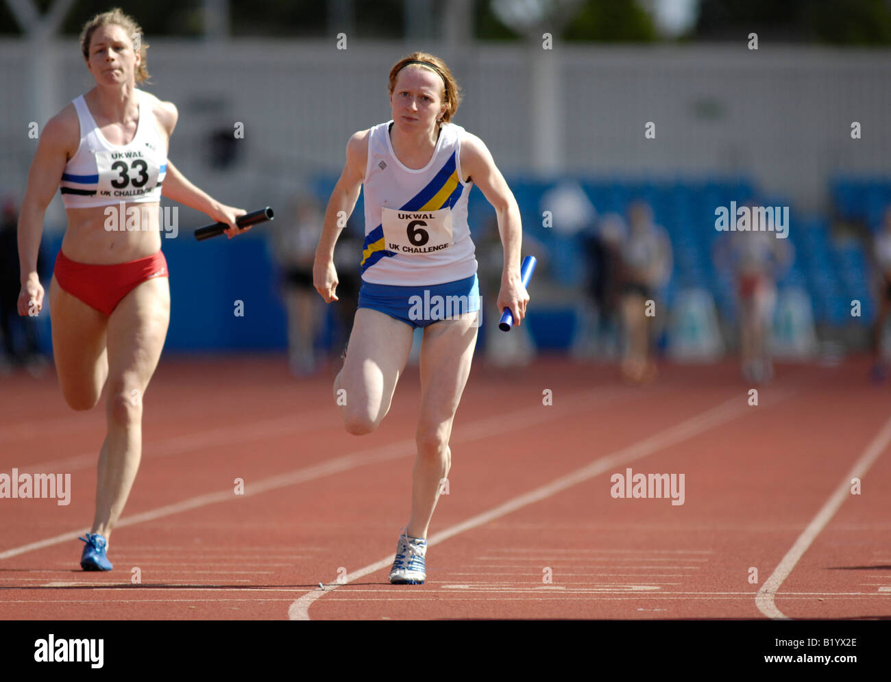 two relay runners sprinting for the line Stock Photo - Alamy