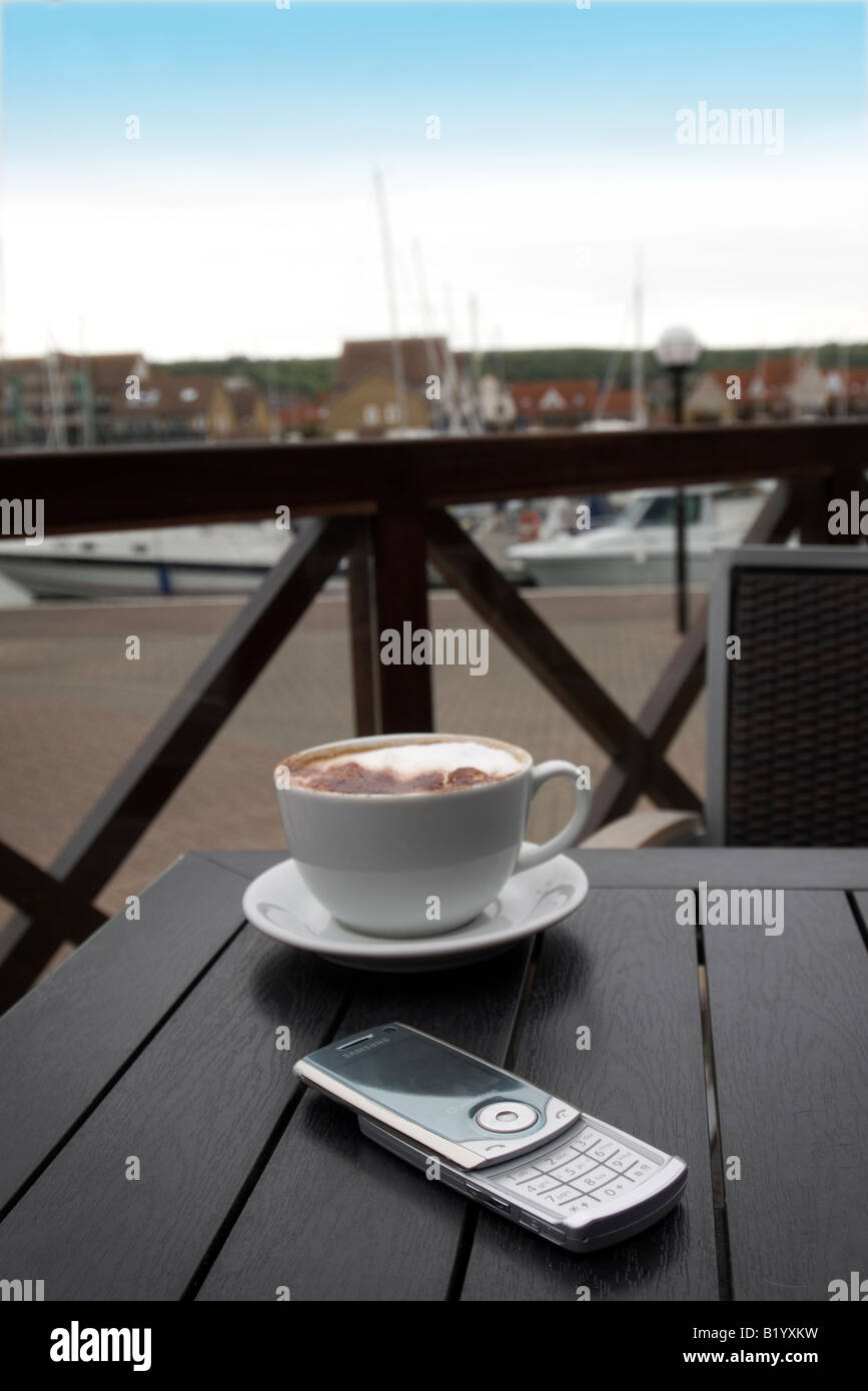 mobile phone on a table with a cup of coffee Stock Photo - Alamy
