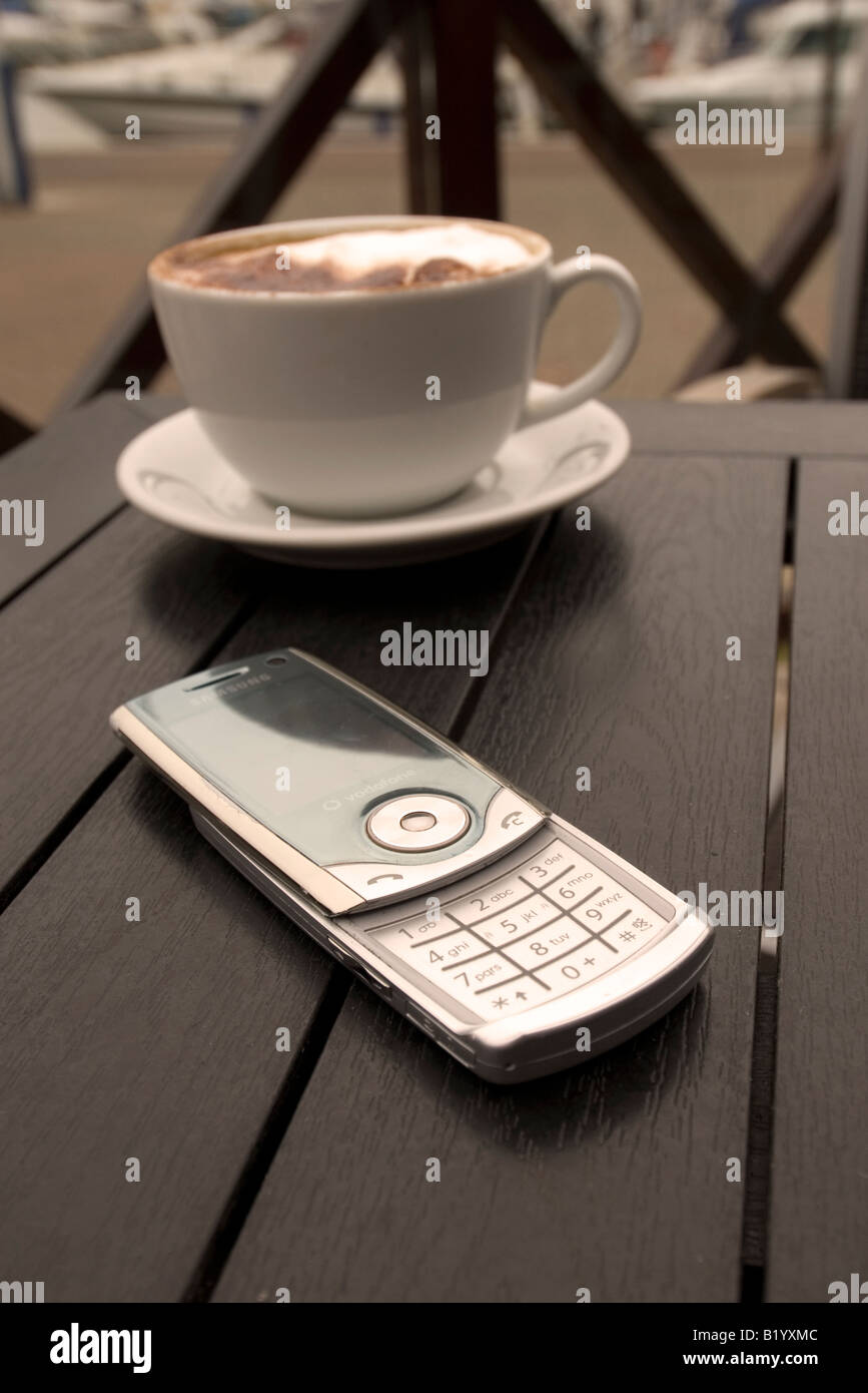 mobile phone on a table with a cup of coffee Stock Photo - Alamy