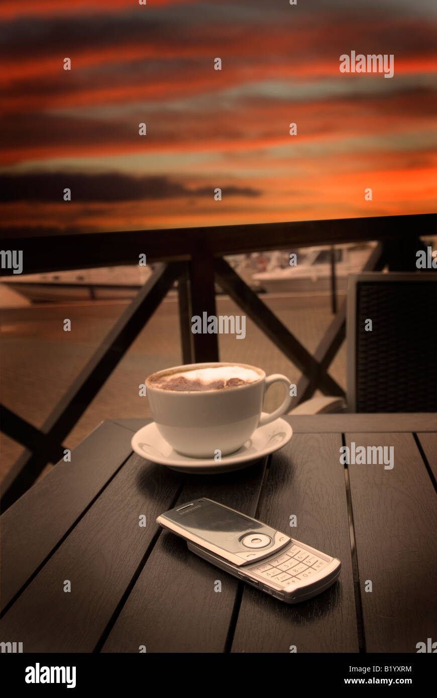 mobile phone with a cup of coffee on a cafe table at sunset Stock Photo ...