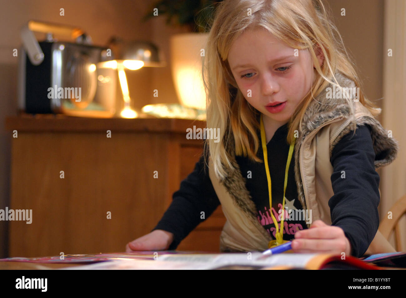 Royalty free photograph of young girl doing homework and working on a ...