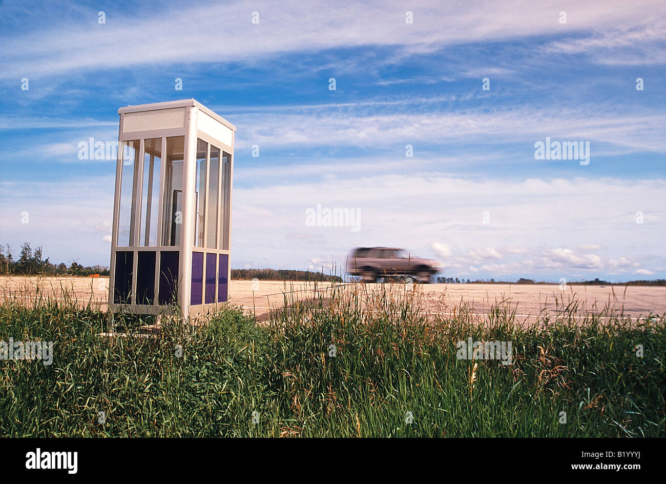 Phone booth on highway sunny day with car driving past Stock Photo - Alamy