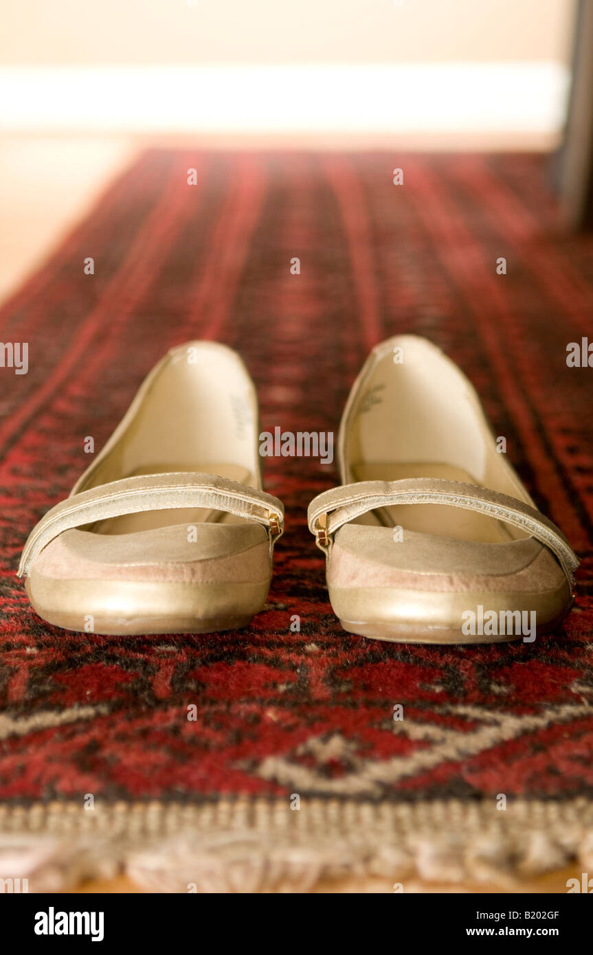 a pair of woman s shoes left behind on the oriental rug Stock Photo - Alamy