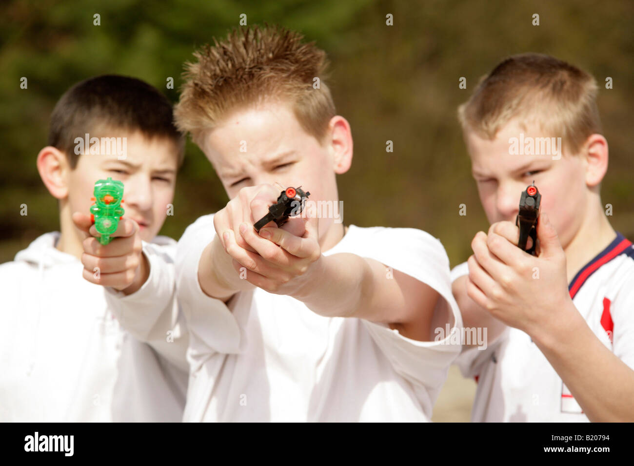 three young boys aiming with toy pistols Stock Photo - Alamy