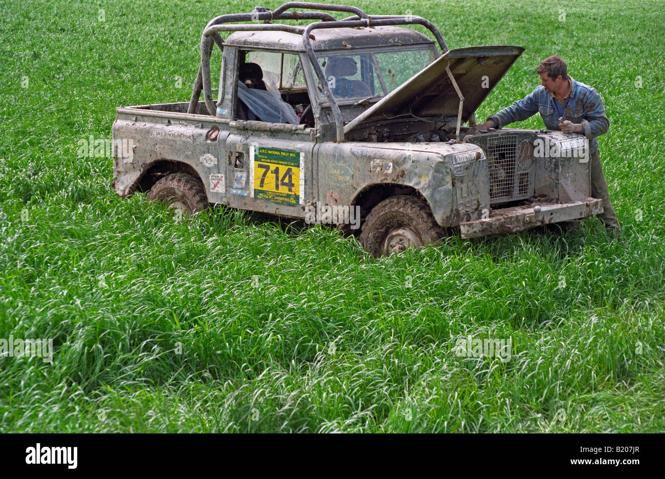 Man in overall repairing a Land Rover Series 2 off-road racer ...
