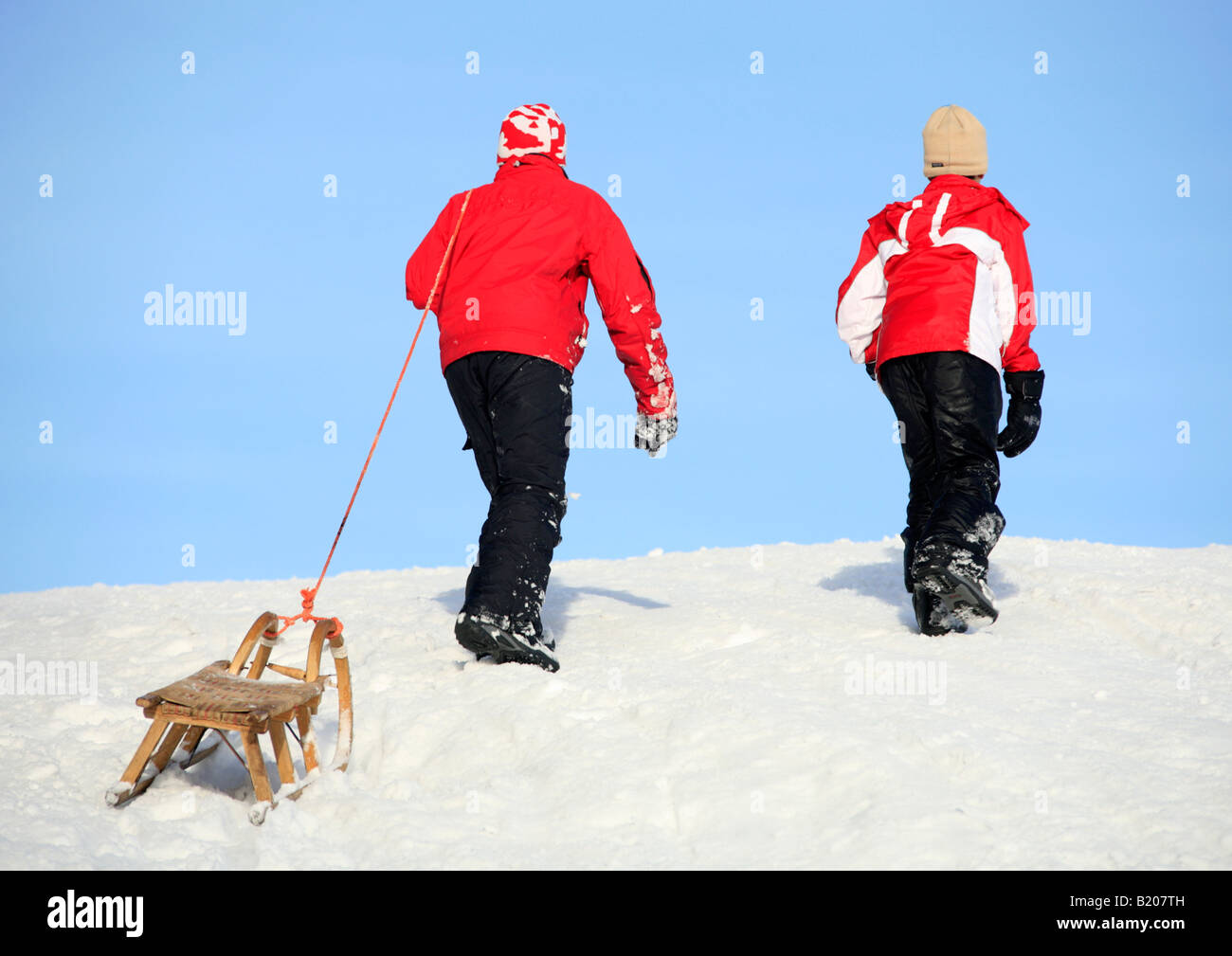 two boys pulling a sledge Stock Photo - Alamy