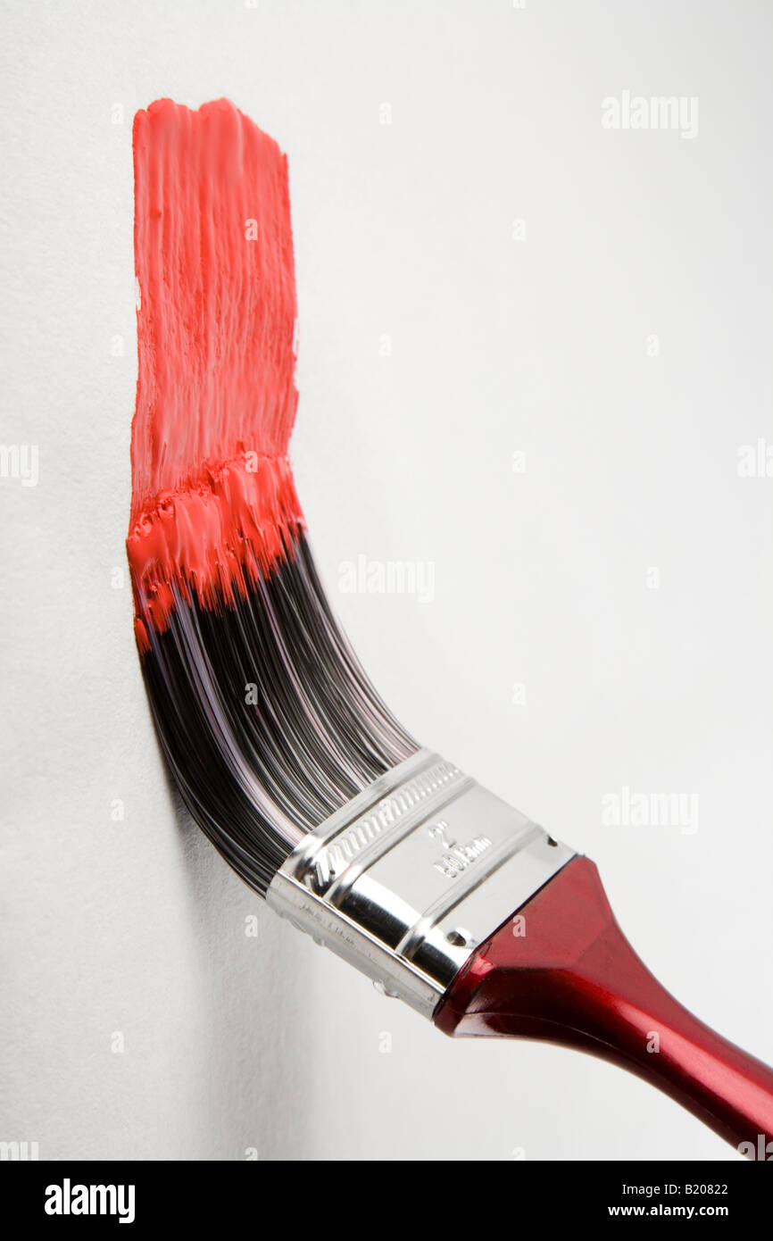 A paint brush loaded with paint on a wall Stock Photo - Alamy