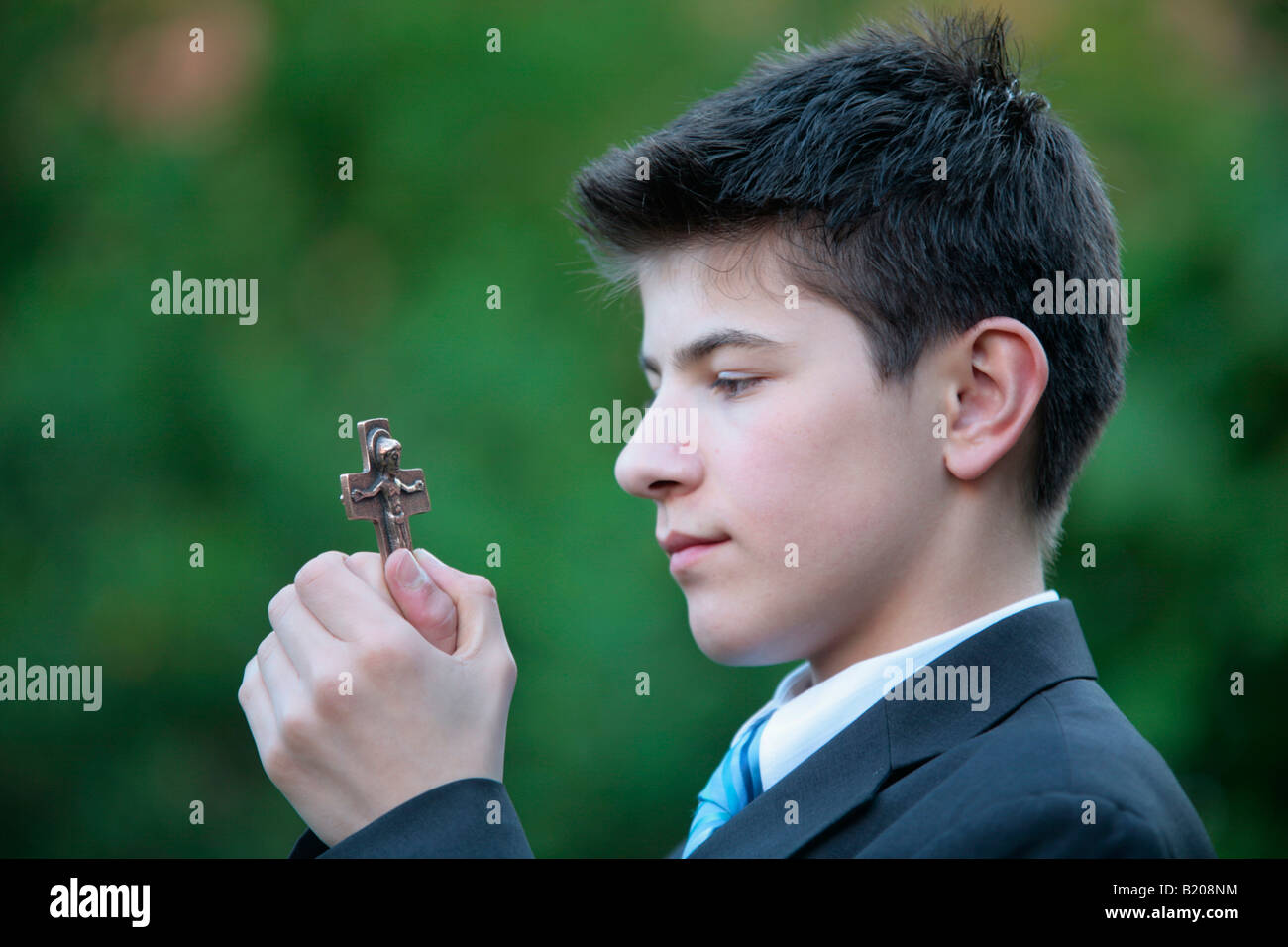 a young boy looking devoutly at the cross he got for his confirmation ...