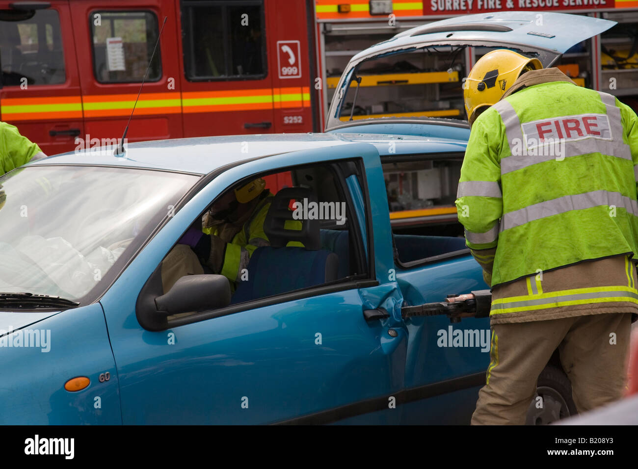 Firecrew using a specialised cutter to prise open a door on a crashed ...
