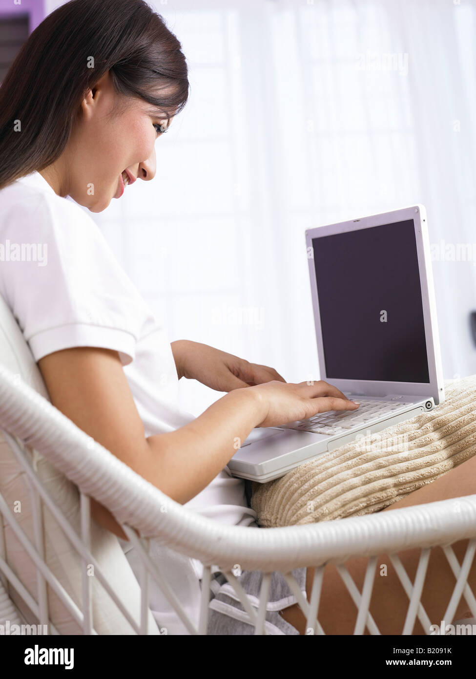Charming girl sitting on her chair using wireless computer Stock Photo ...