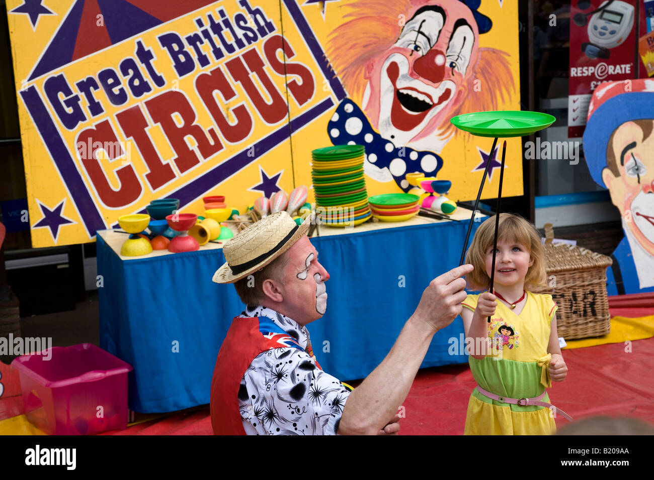 A clown receiving help from a young volunteer, Haslemere, Surrey ...