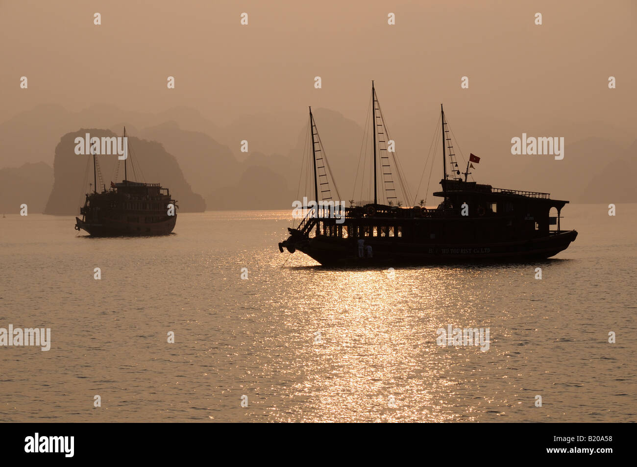 Traditional sailing junks at sunset Ha Long Bay Vietnam Stock Photo - Alamy