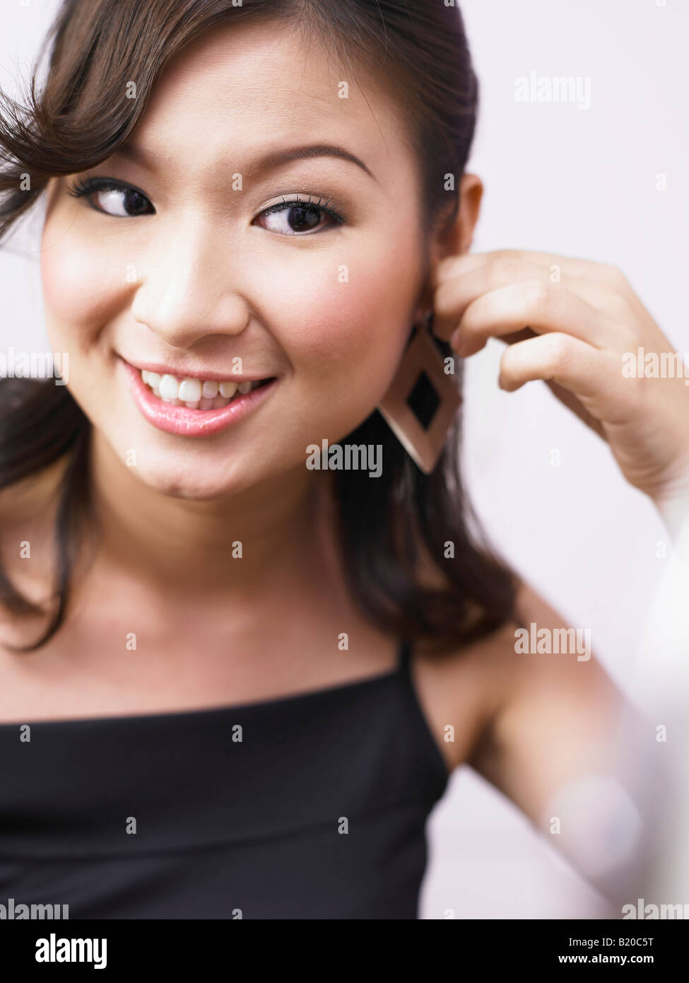 Pretty woman trying her ear ring Stock Photo - Alamy