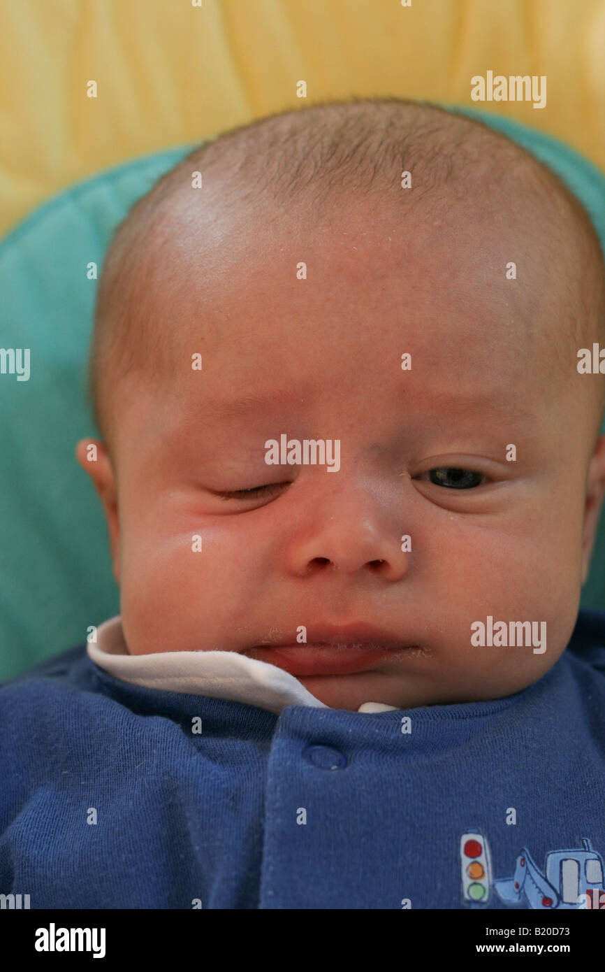 Sleepy baby boy at 12 weeks winking Stock Photo - Alamy