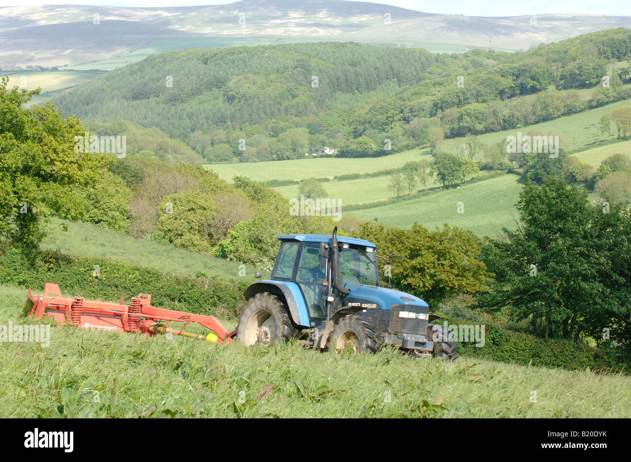 silage grass cutting on a farm in Devon with Dartmoor in the back ...