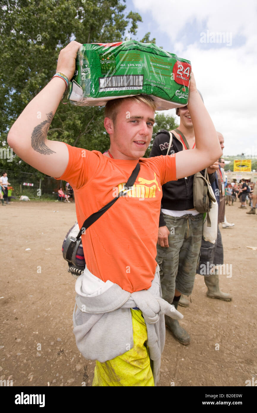 Man carrying a crate of beer on his head at the Glastonbury Festival ...