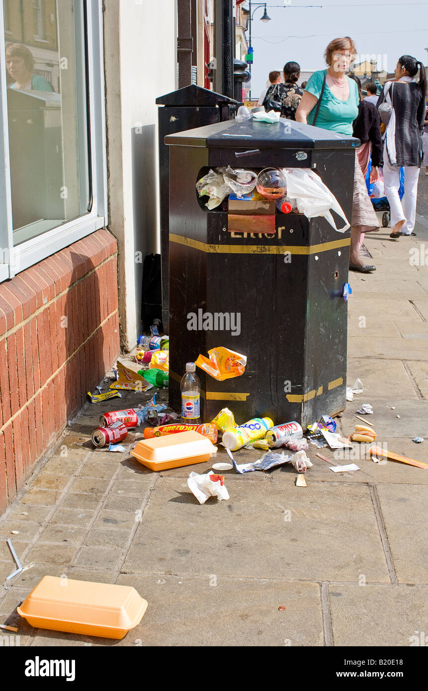 A photograph of a litter bin overflowing with rubbish deposited by ...