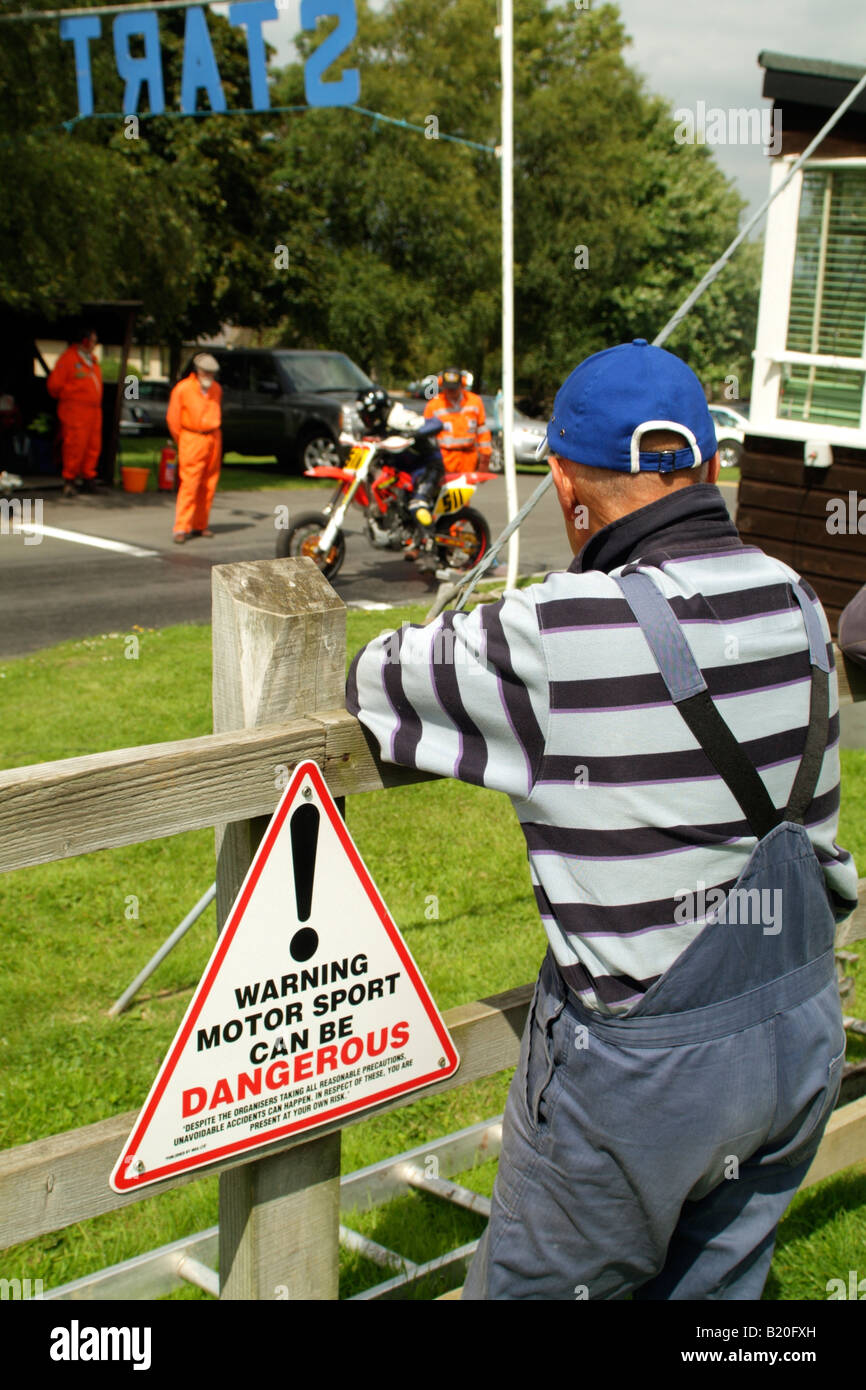 Motor sporting event track danger sign and supporter Stock Photo - Alamy