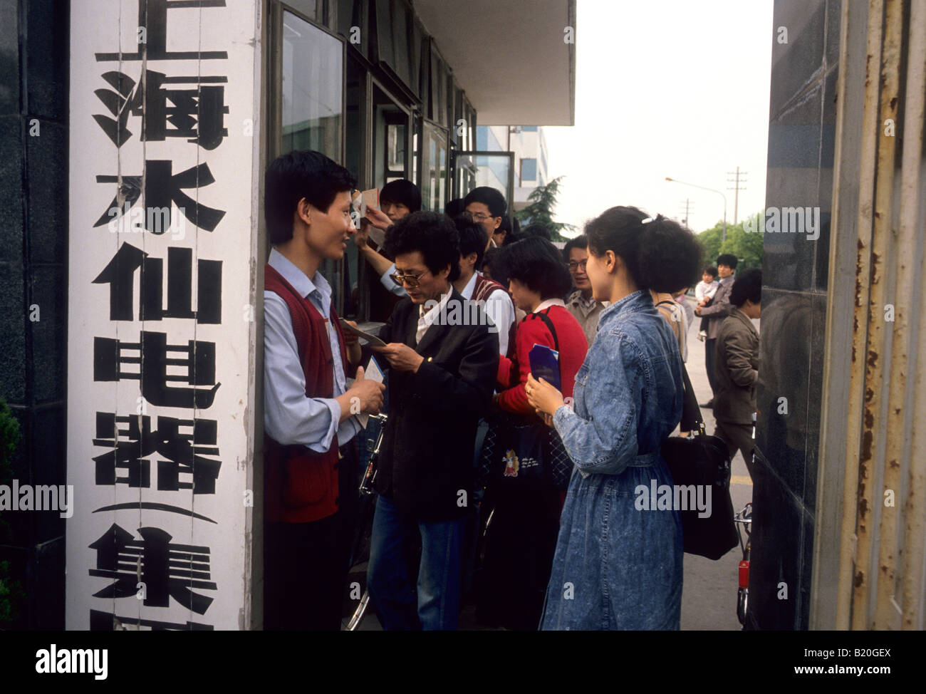 Chinese workers punch a time clock at a factory gate in Shanghai China ...