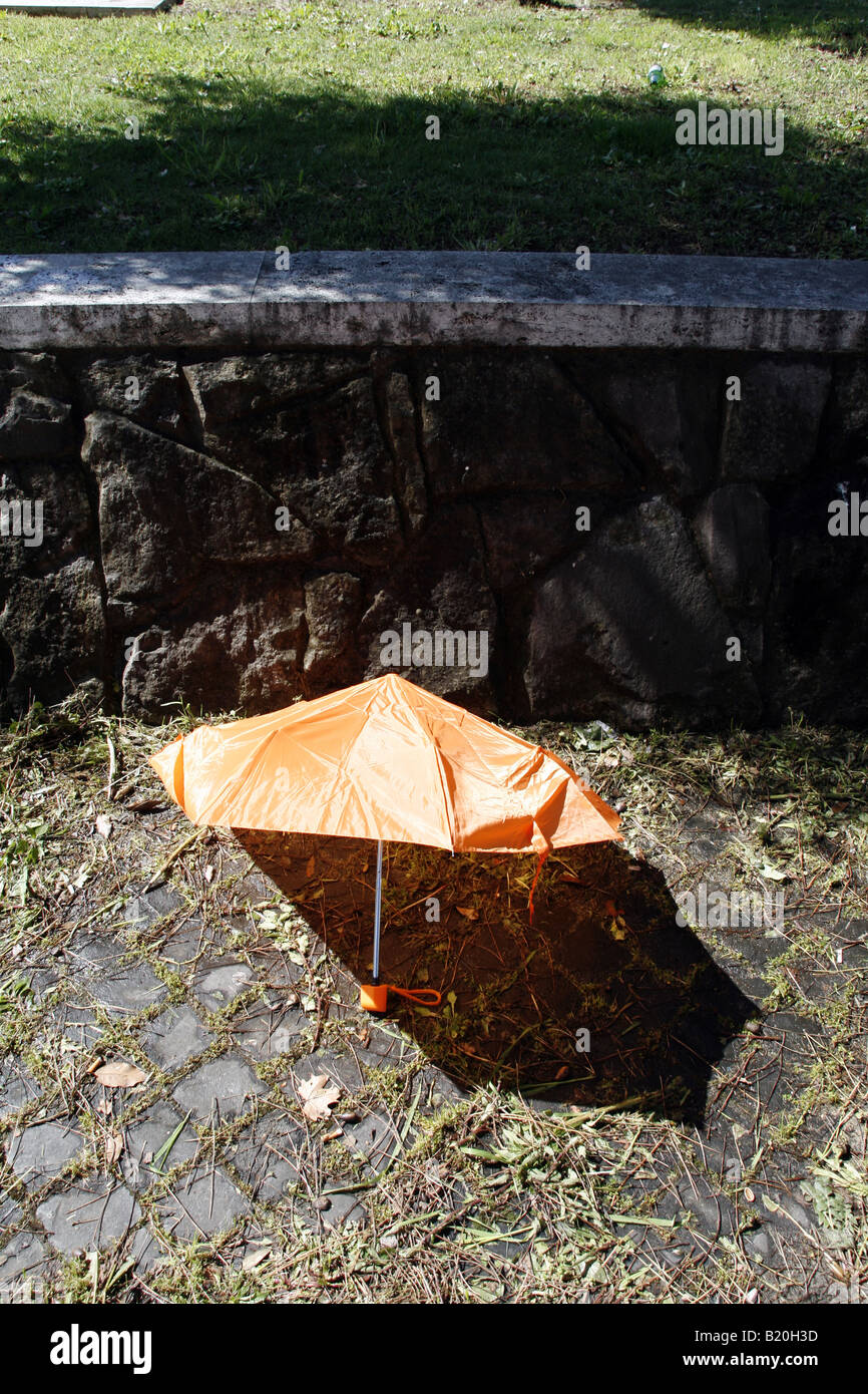 old orange umbrella left on pavement in town Stock Photo - Alamy