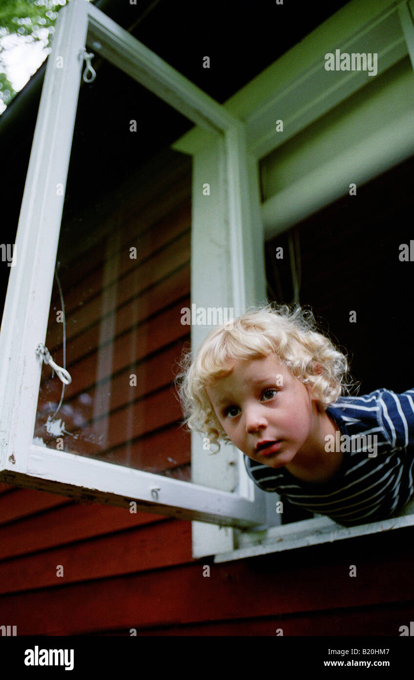 Child leaning out of an open window Stock Photo - Alamy