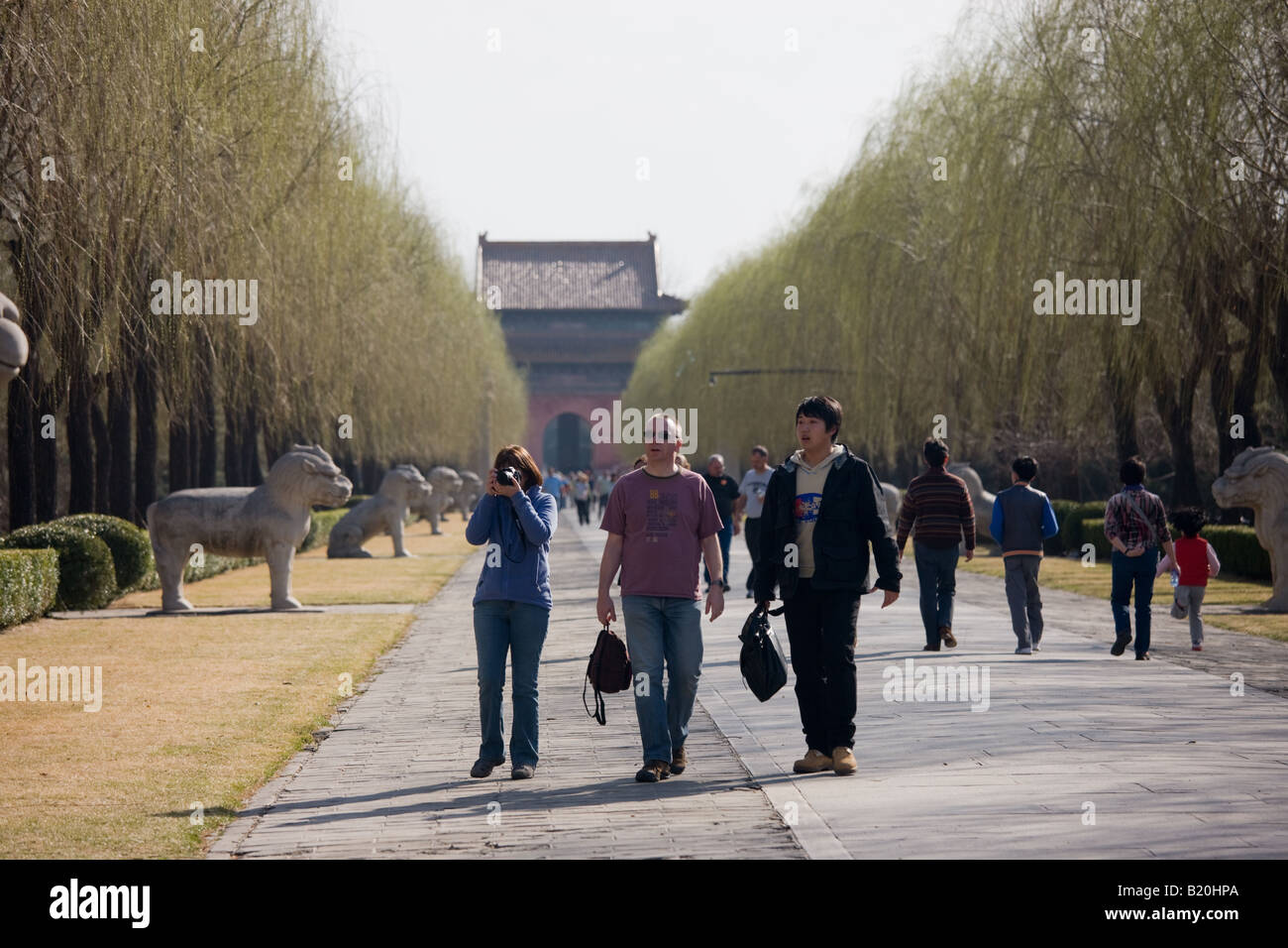 Western tourists with Chinese guide walk along the Spirit Way at the ...