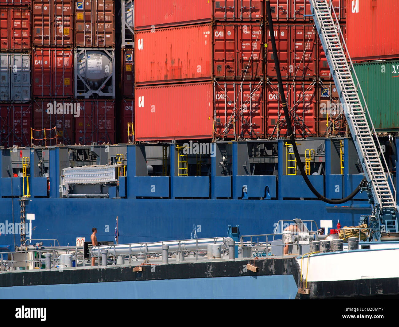 Supply ship moored next to a very large container ship in the seaport ...