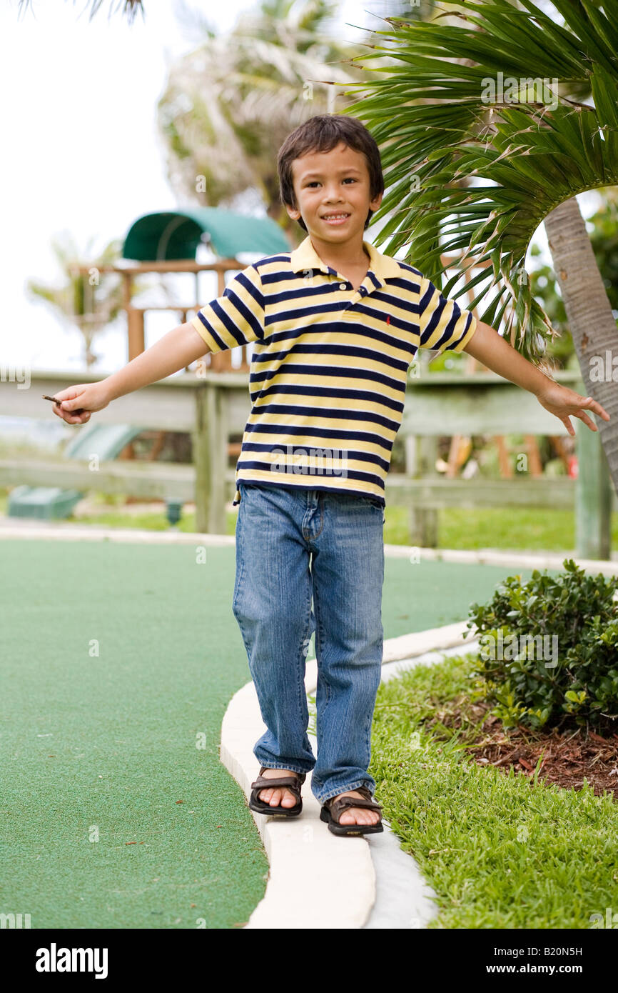 Boy walking with his arms out to the side Stock Photo - Alamy