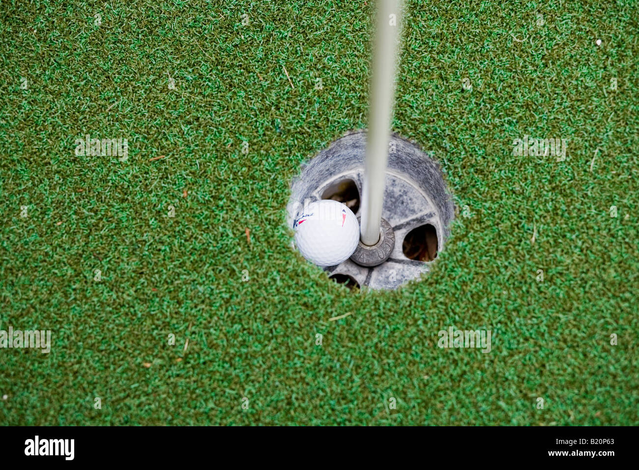 Golf ball in hole, miniature golf Stock Photo - Alamy