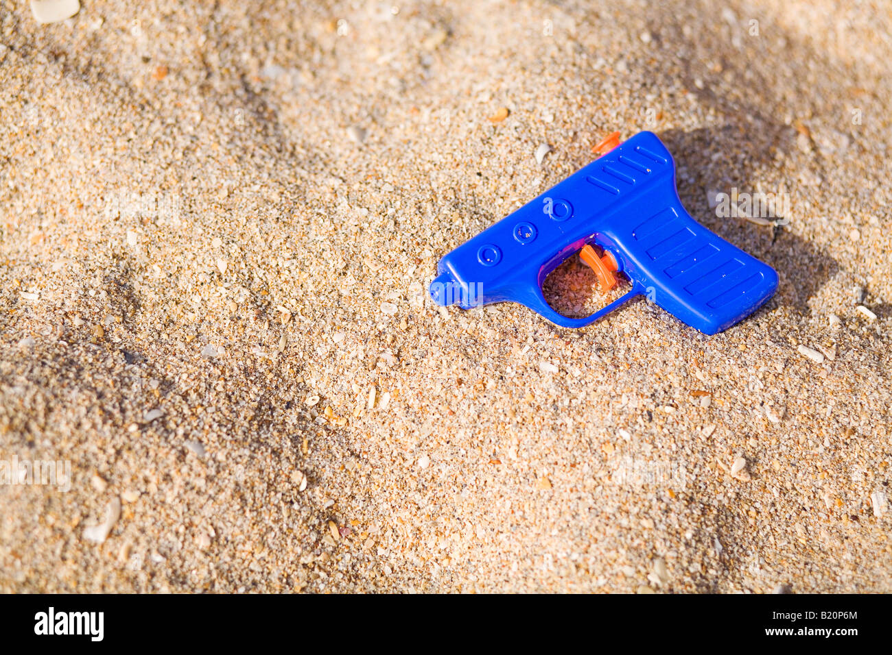 Blue water gun in the sand on the beach Stock Photo - Alamy