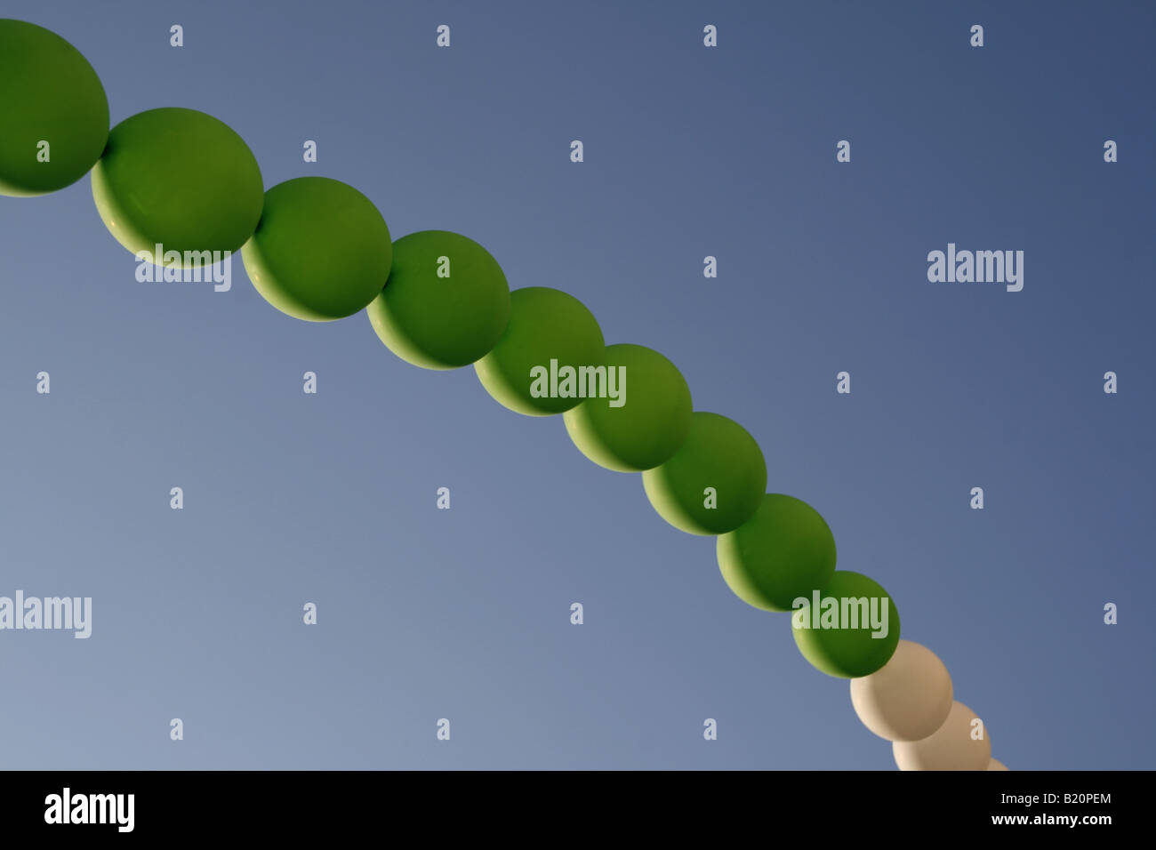 long line of green white balloons in blue sky Stock Photo - Alamy
