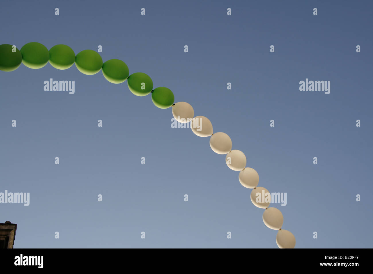 long line of green white balloons in blue sky Stock Photo - Alamy