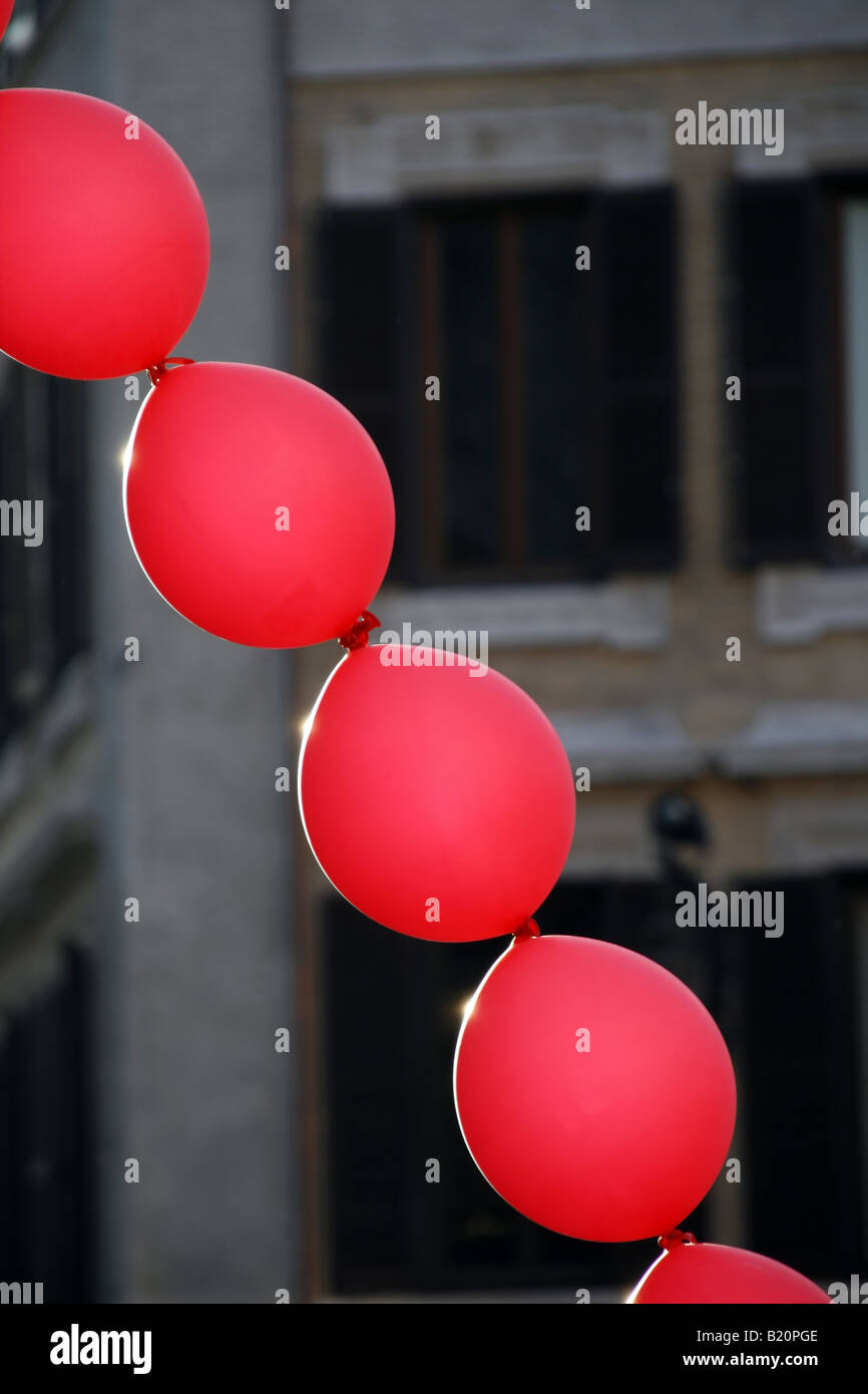 silhouette of long line of red balloons in city Stock Photo - Alamy
