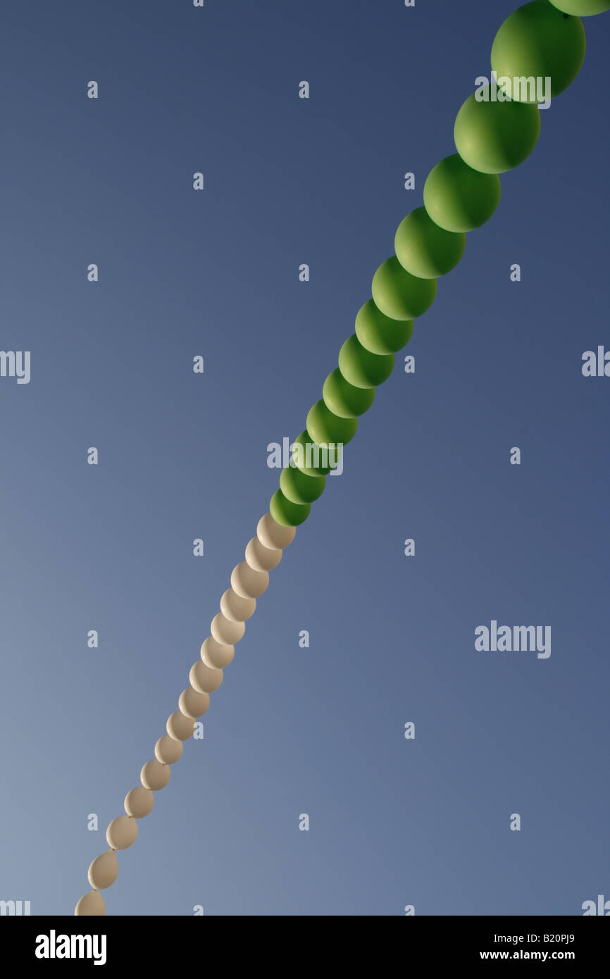 long line of green white balloons in blue sky Stock Photo - Alamy