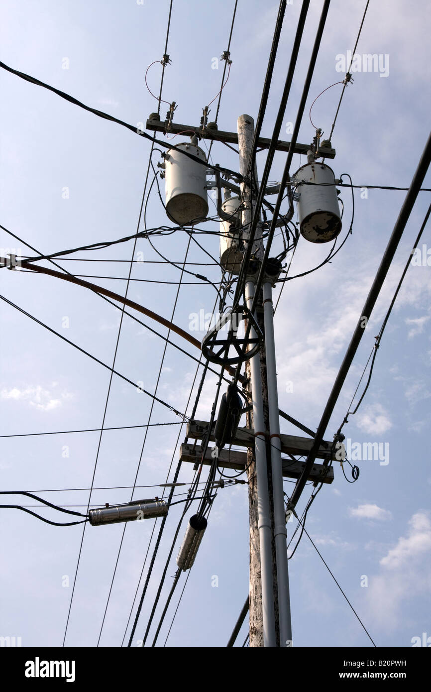 Powerlines converging in a power line pole in town high above the ...
