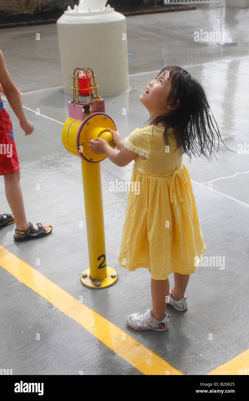A Chinese Girl operates water cannon at a water park and watches the ...