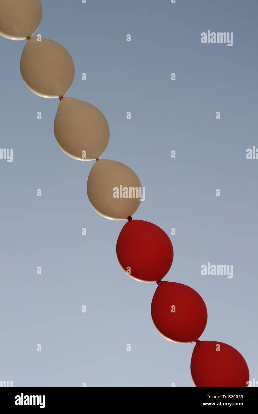 long line of red white balloons in blue sky Stock Photo - Alamy