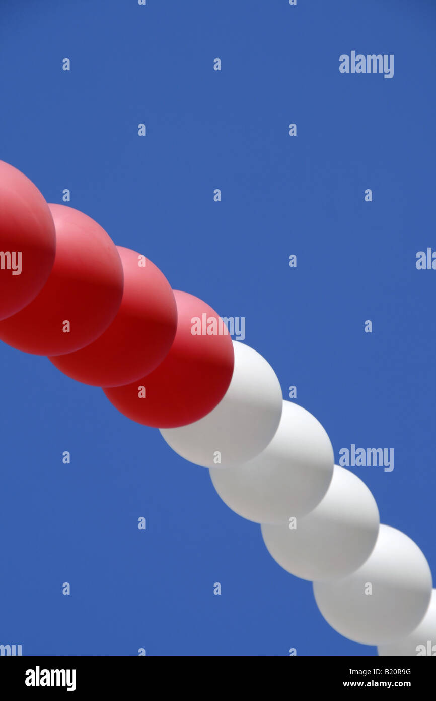 long line of red white balloons in blue sky Stock Photo - Alamy