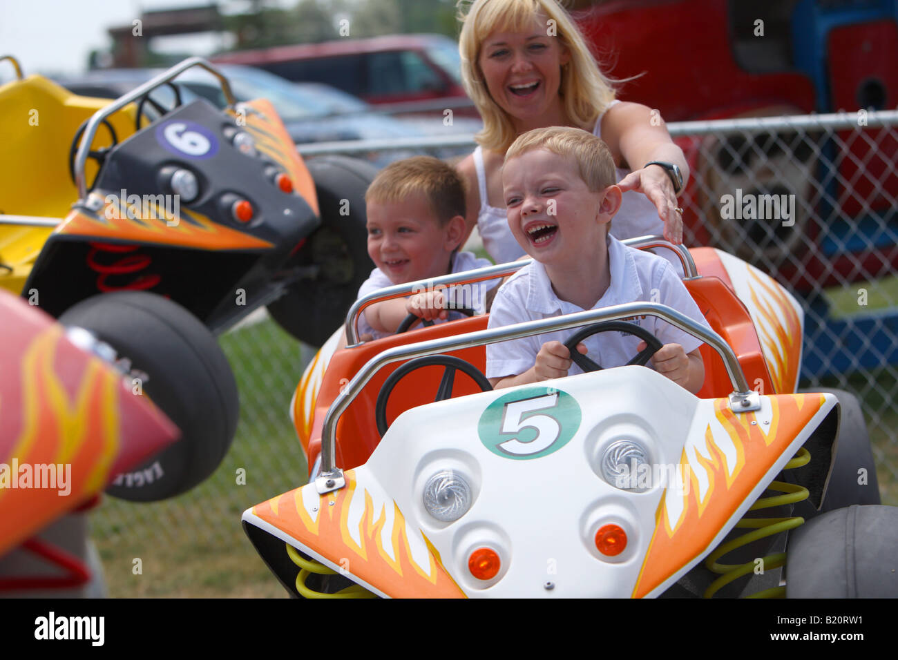 Mom and two young boys on amusement park ride Stock Photo - Alamy