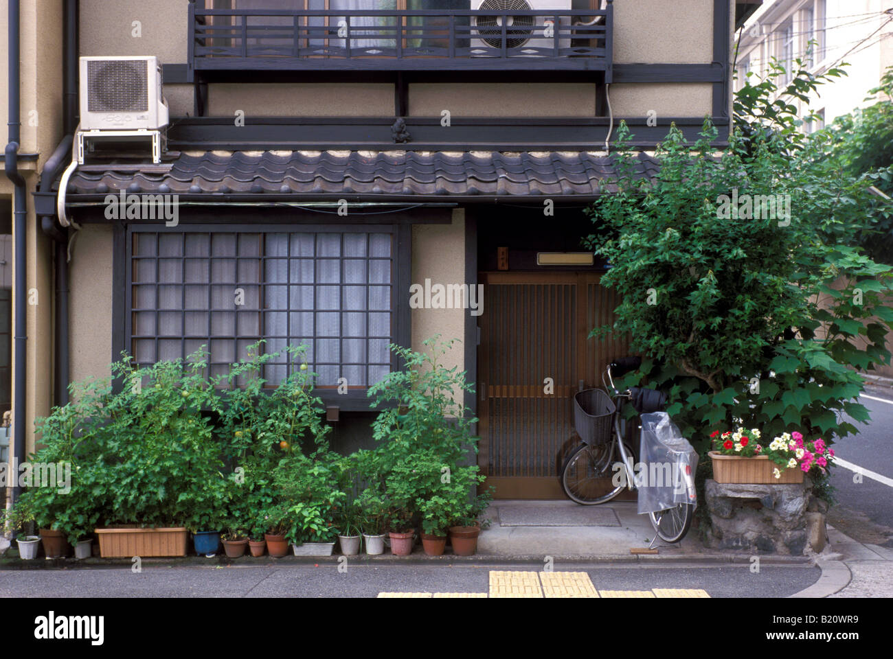 A typical machiya style two storey residence in Kyoto city with potted ...