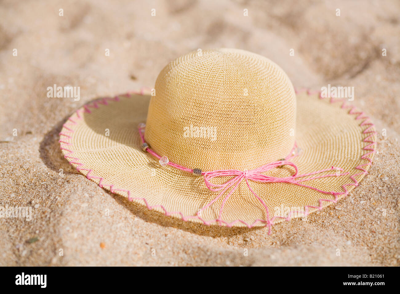 Woven sun hat in the sand on the beach Stock Photo - Alamy